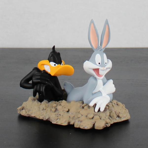 Daffy Duck in the rabbit hole with Bugs Bunny figurine