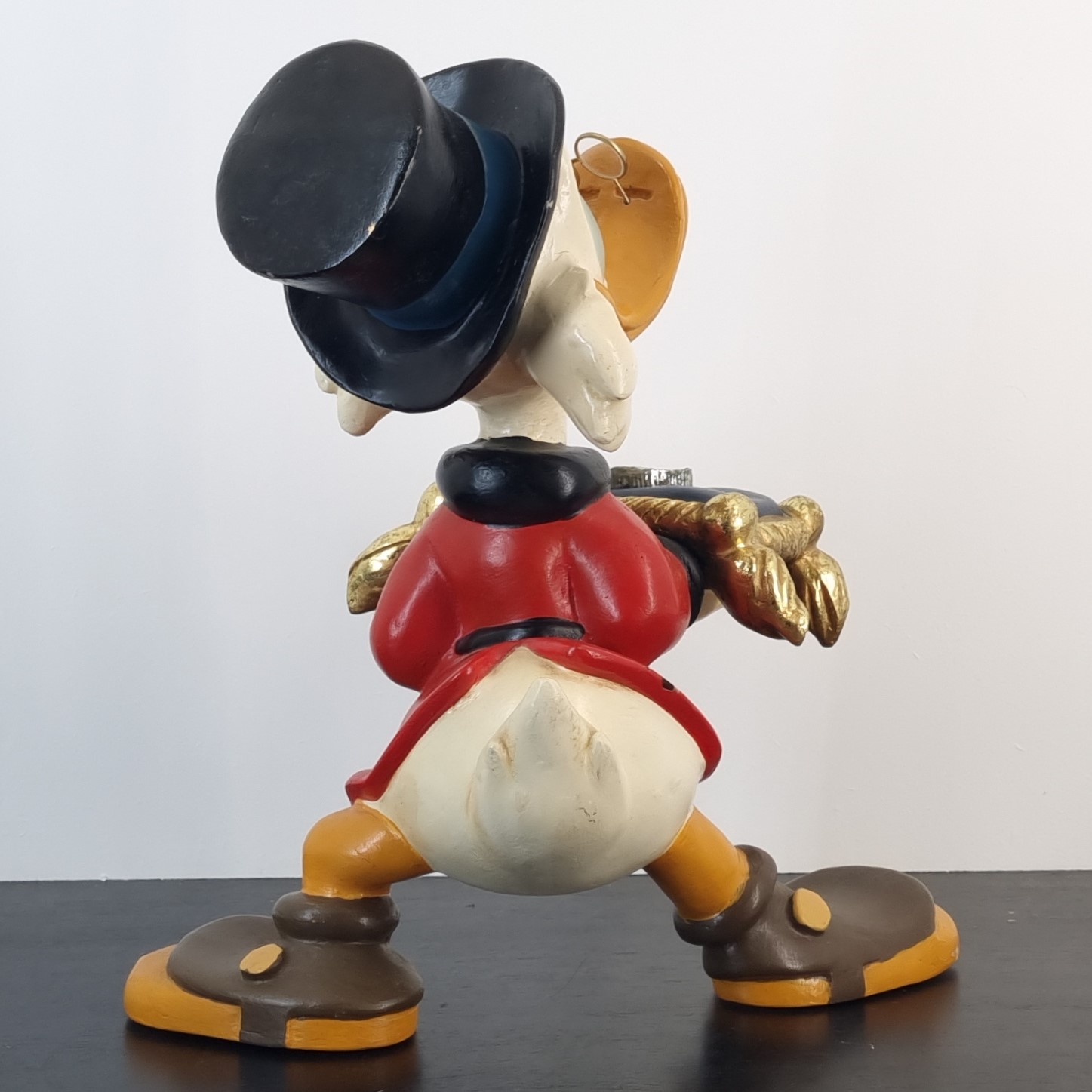 Scrooge McDuck with his lucky dime on a pillow statue