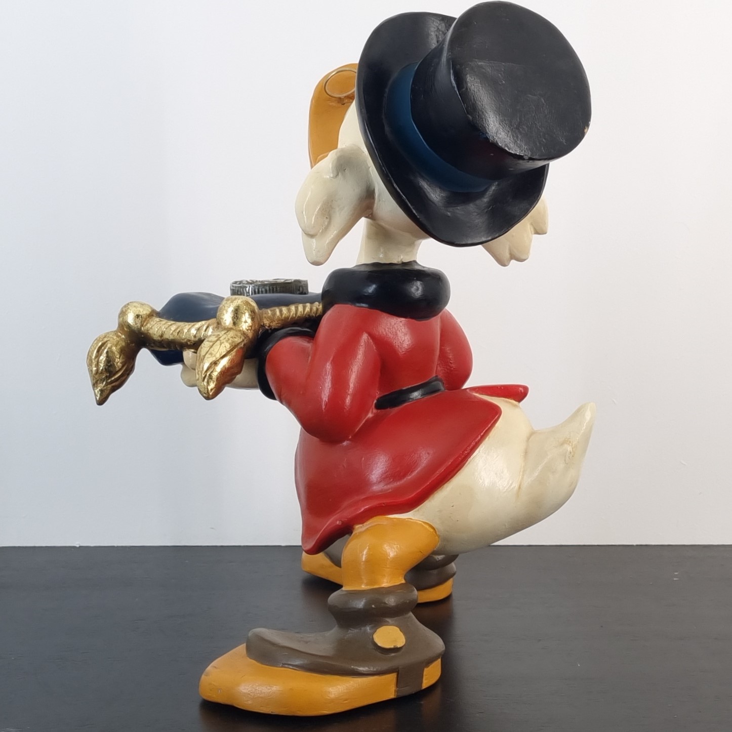 Scrooge McDuck with his lucky dime on a pillow statue